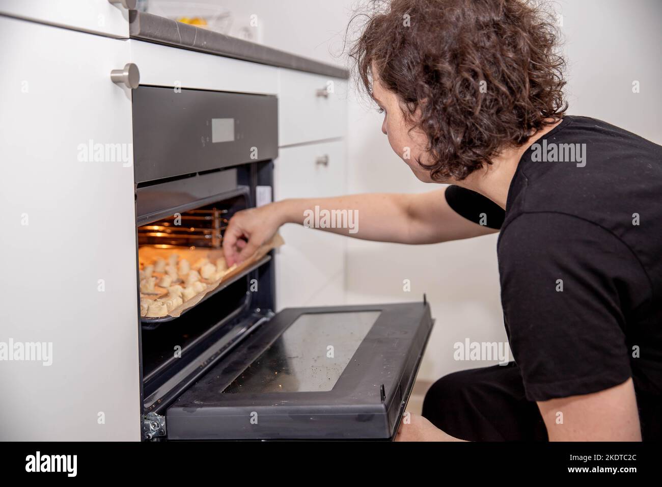 Woman baking cookies in oven hi-res stock photography and images - Alamy