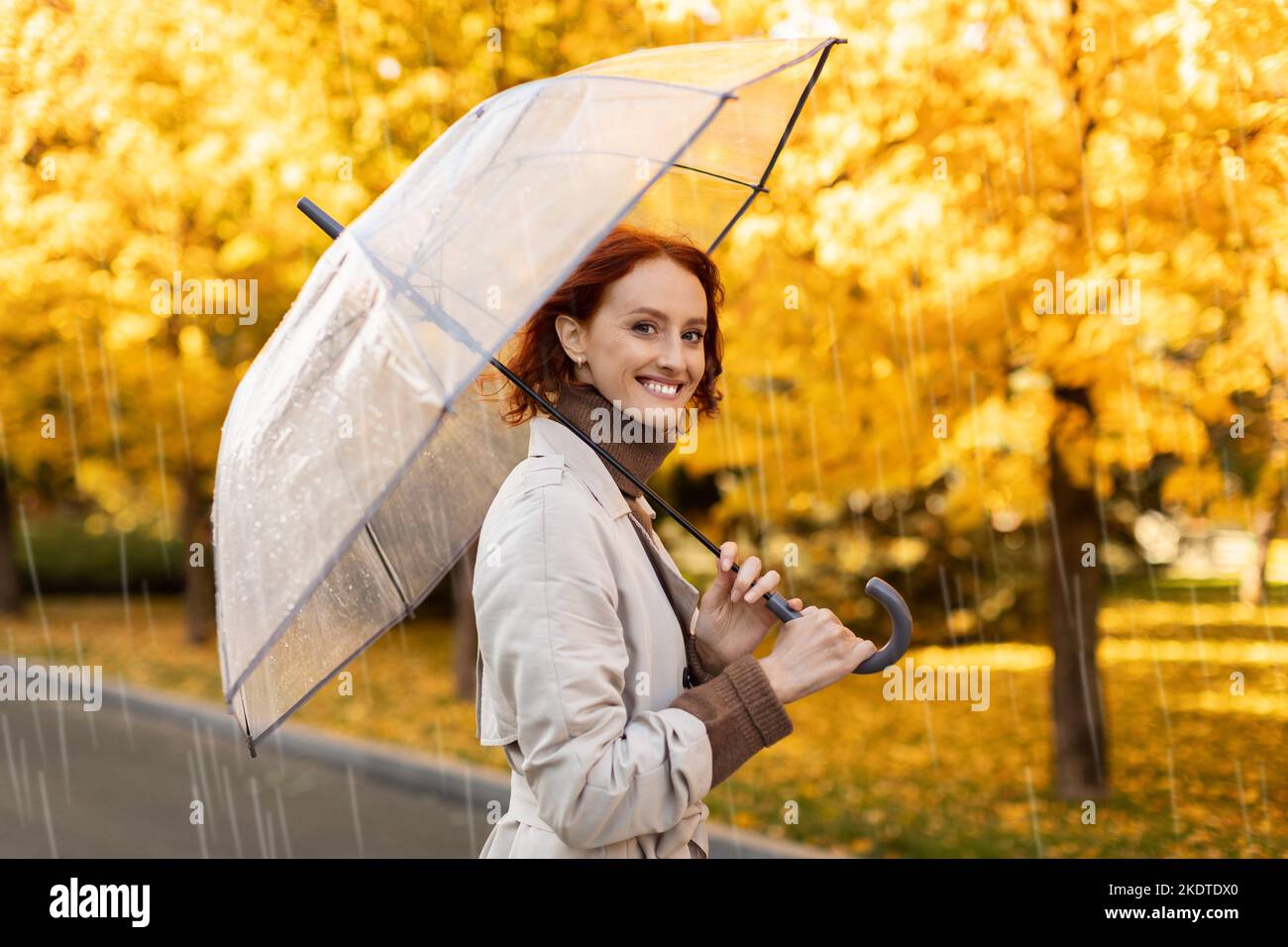 Cheerful Caucasian Millennial Lady With Red Hair In Raincoat With