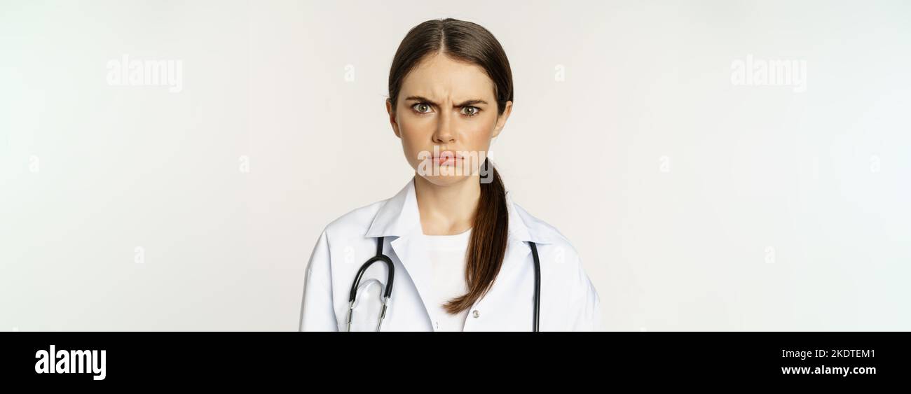 Angry and upset young woman doctor, female healthcare worker sulking ...