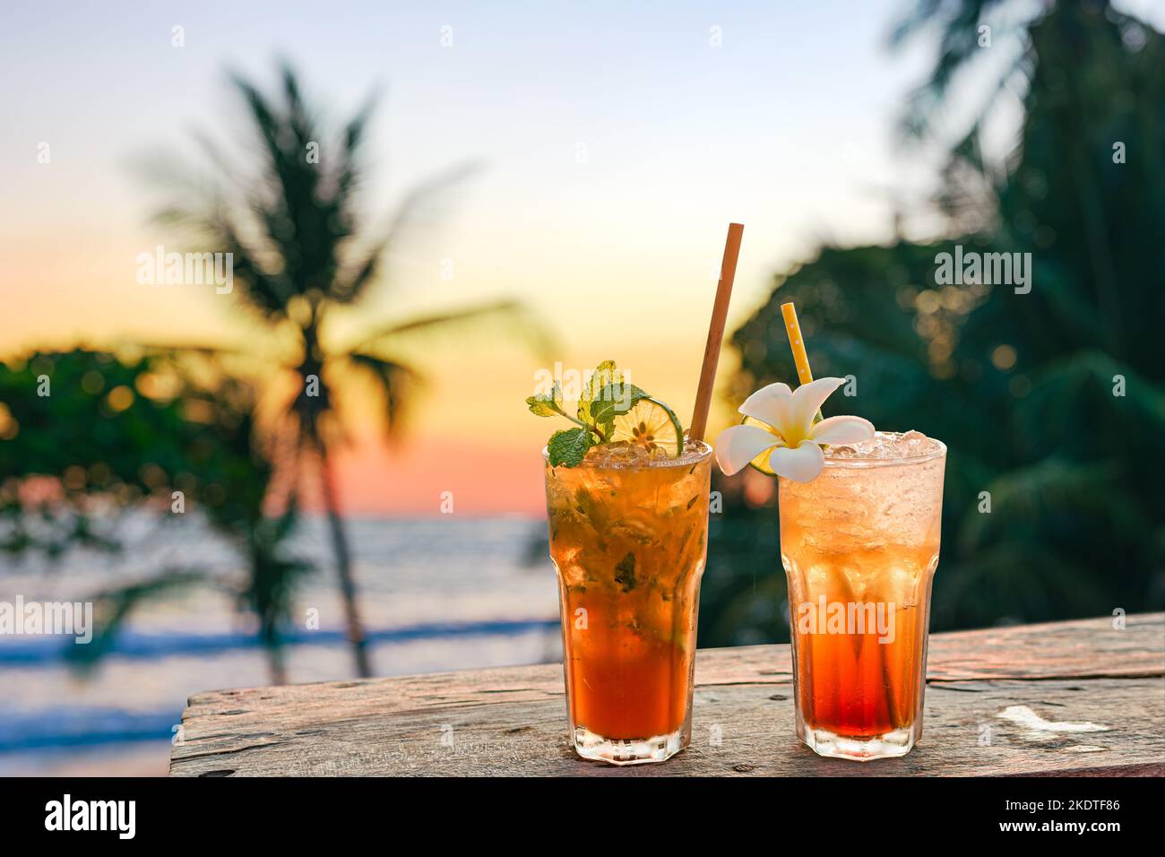 drinks with blur beach and sunset in background Stock Photo - Alamy