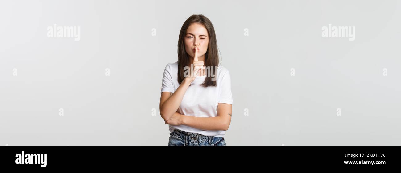 Sassy attractive brunette girl winking, shushing at camera, have secret ...