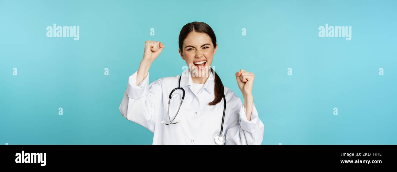 Enthusiastic doctor woman, rejoicing, winning and celebrating, achieve ...