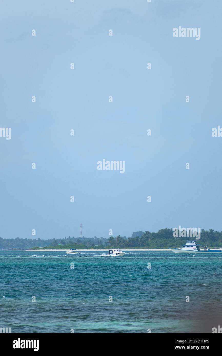 A picture of a speed boat moving towards a cruise boat in the blue sea ...
