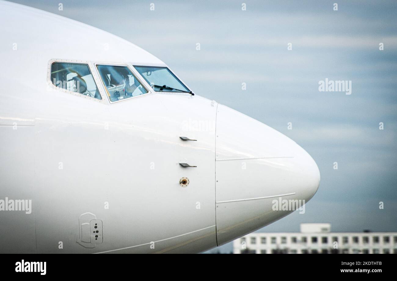A modern passenger plane in white livery at the international airport ...