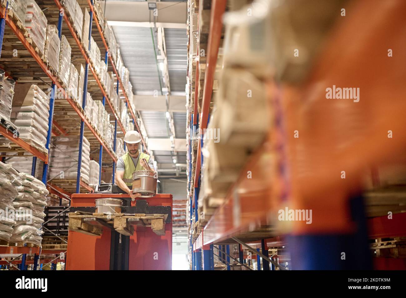 Serious young warehouse loader dealing with good Stock Photo - Alamy