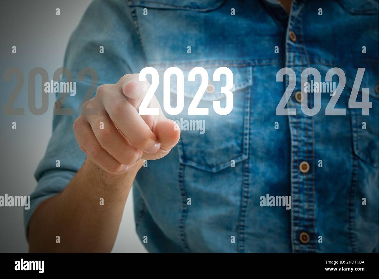 Finger pressing blue start 2023 button on virtual interface on gray ...