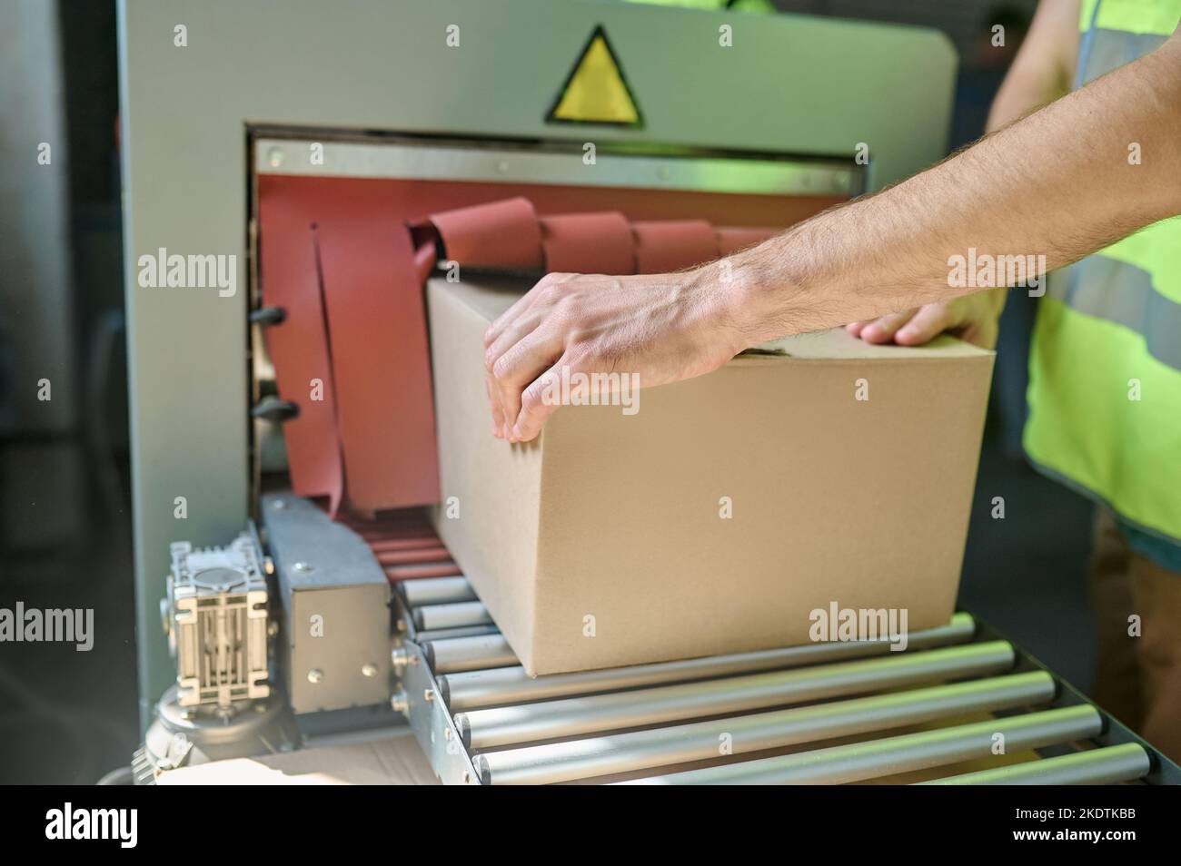Warehouse worker packing wares using industrial equipment Stock Photo ...