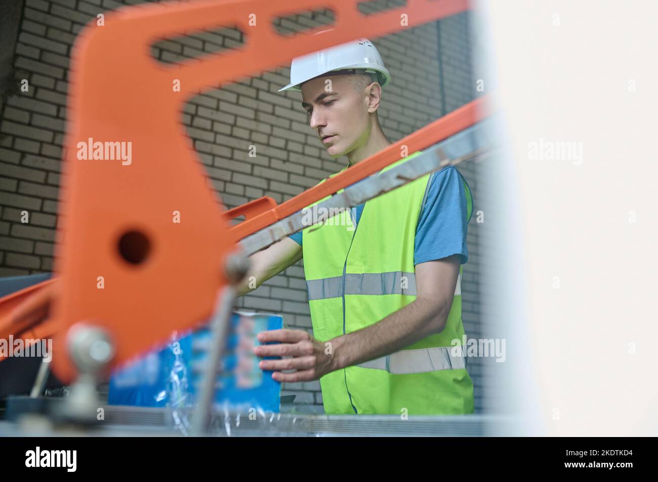 Experienced warehouse operator using automated machinery for packing ...