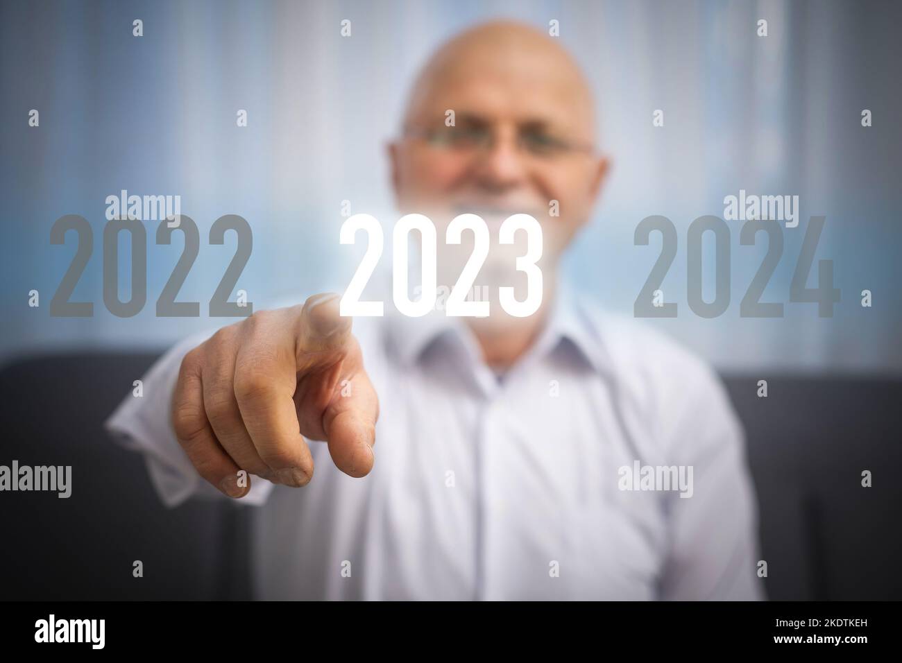 Finger pressing blue start 2023 button on virtual interface on gray ...