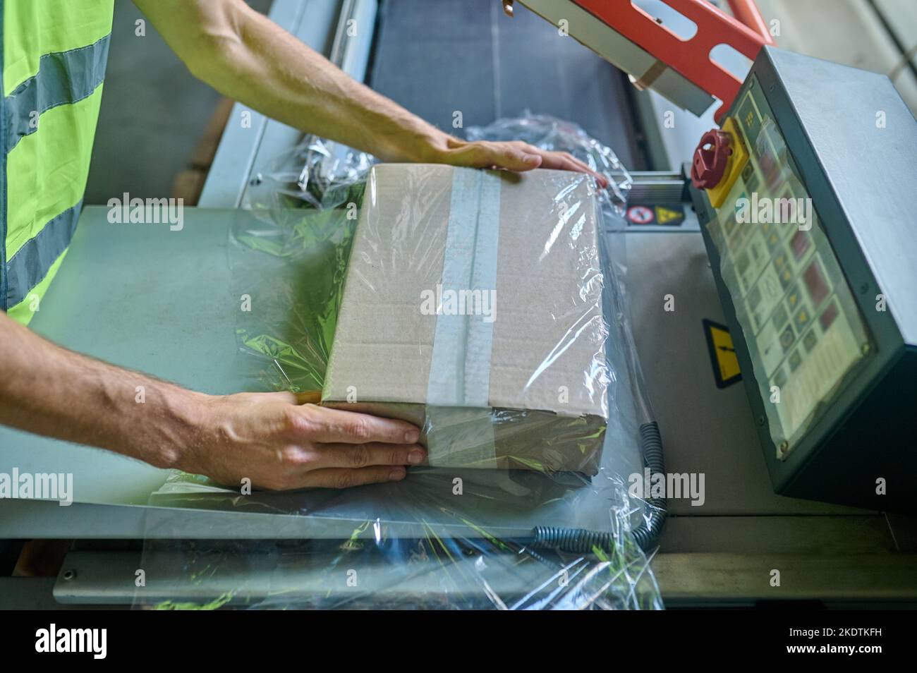 Worker packing merchandise applying modern industrial equipment Stock ...