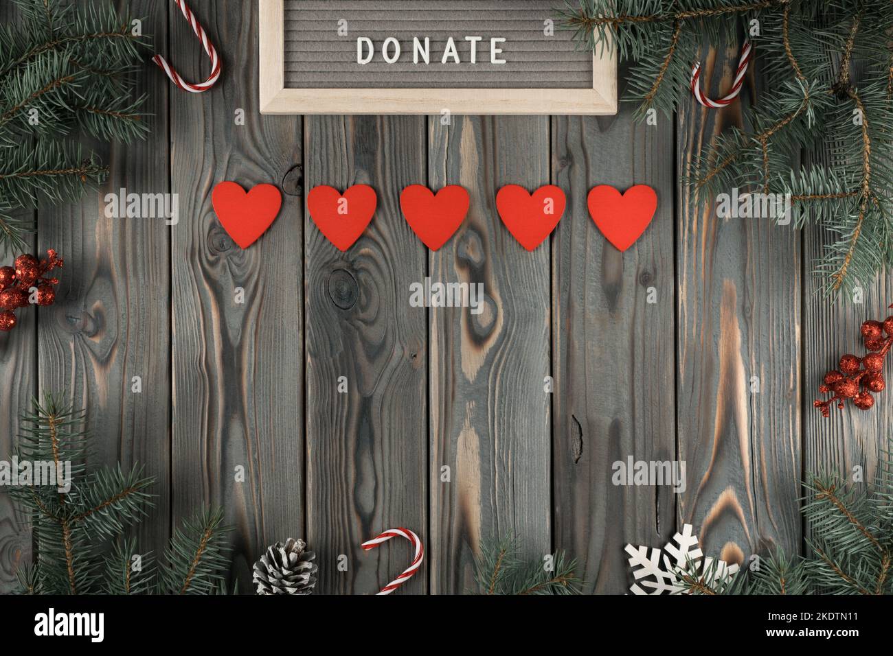 Donation abstract composition with red heart garland on dark wooden ...