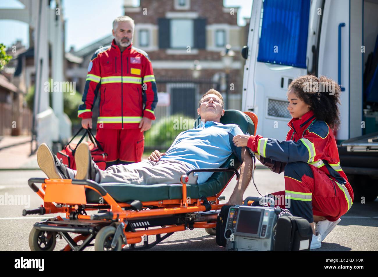 Female paramedic providing emergency medical care to an unconscious ...