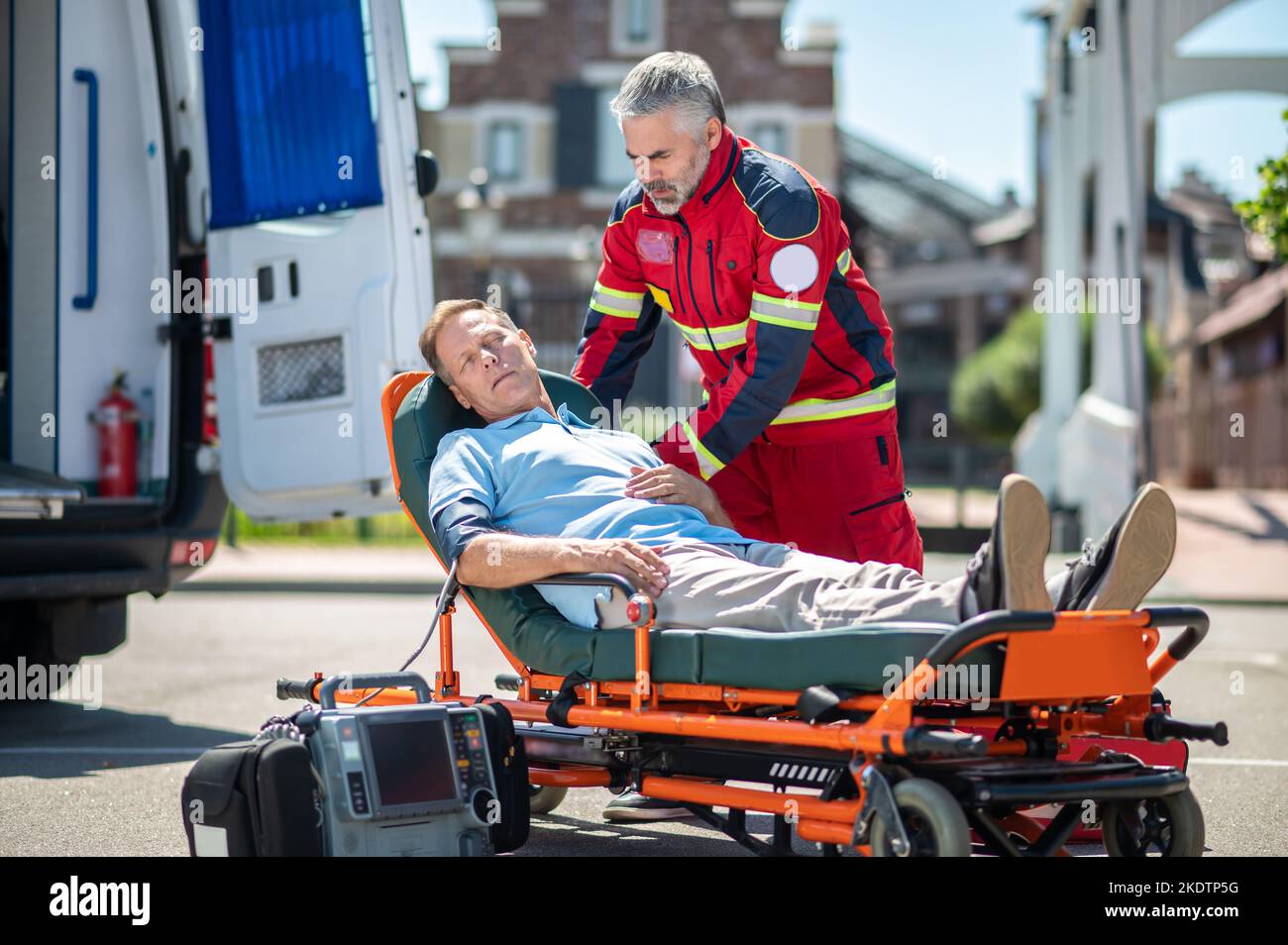 Concentrated ambulance doctor assessing the patient condition Stock ...