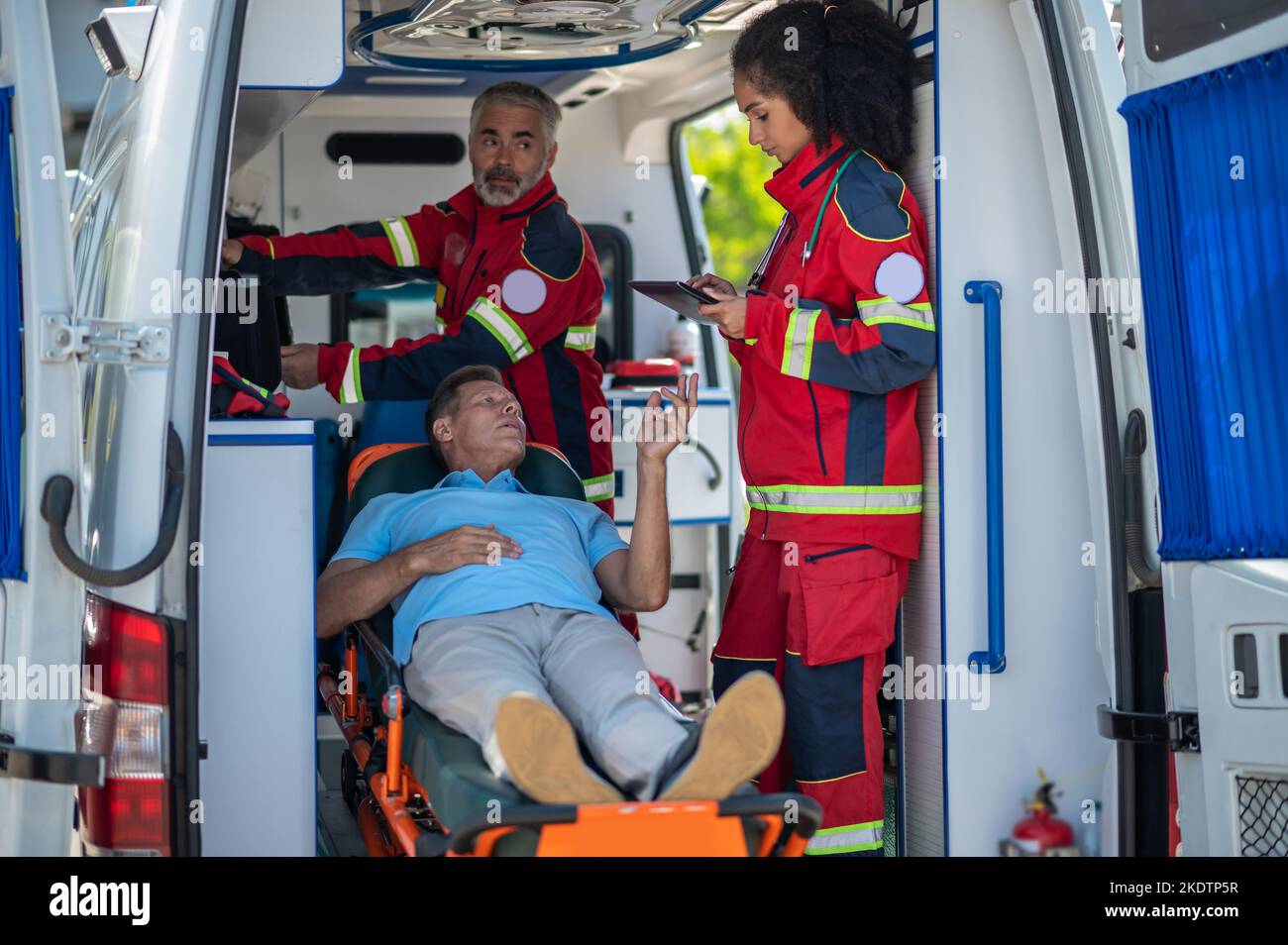 Ambulance staff listening to the sick man complaints Stock Photo - Alamy