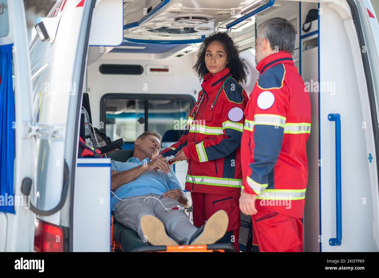 Ambulance staff monitoring the oxygenation status of an unconscious ...