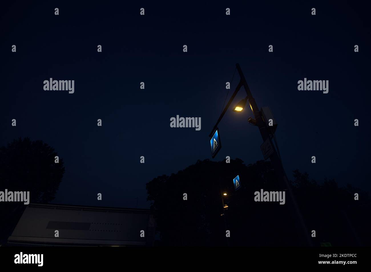 Illuminated sign by a pedestrian crossing at dusk Stock Photo - Alamy