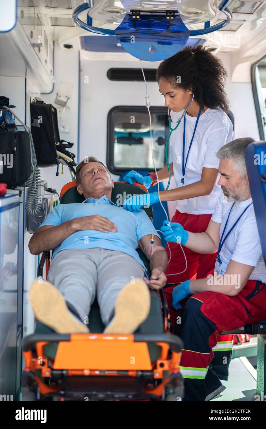 Paramedical team providing emergency medical care to an ill person ...