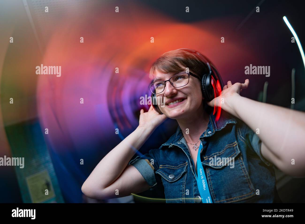 a woman with headphones at a silent disco in a library Stock Photo - Alamy