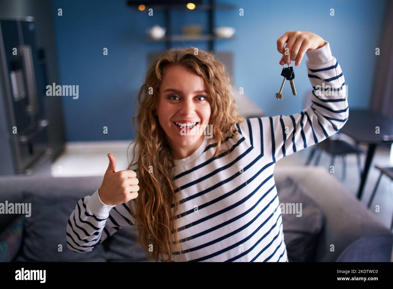 Happy woman showing new house or apartment keys to camera in modern ...