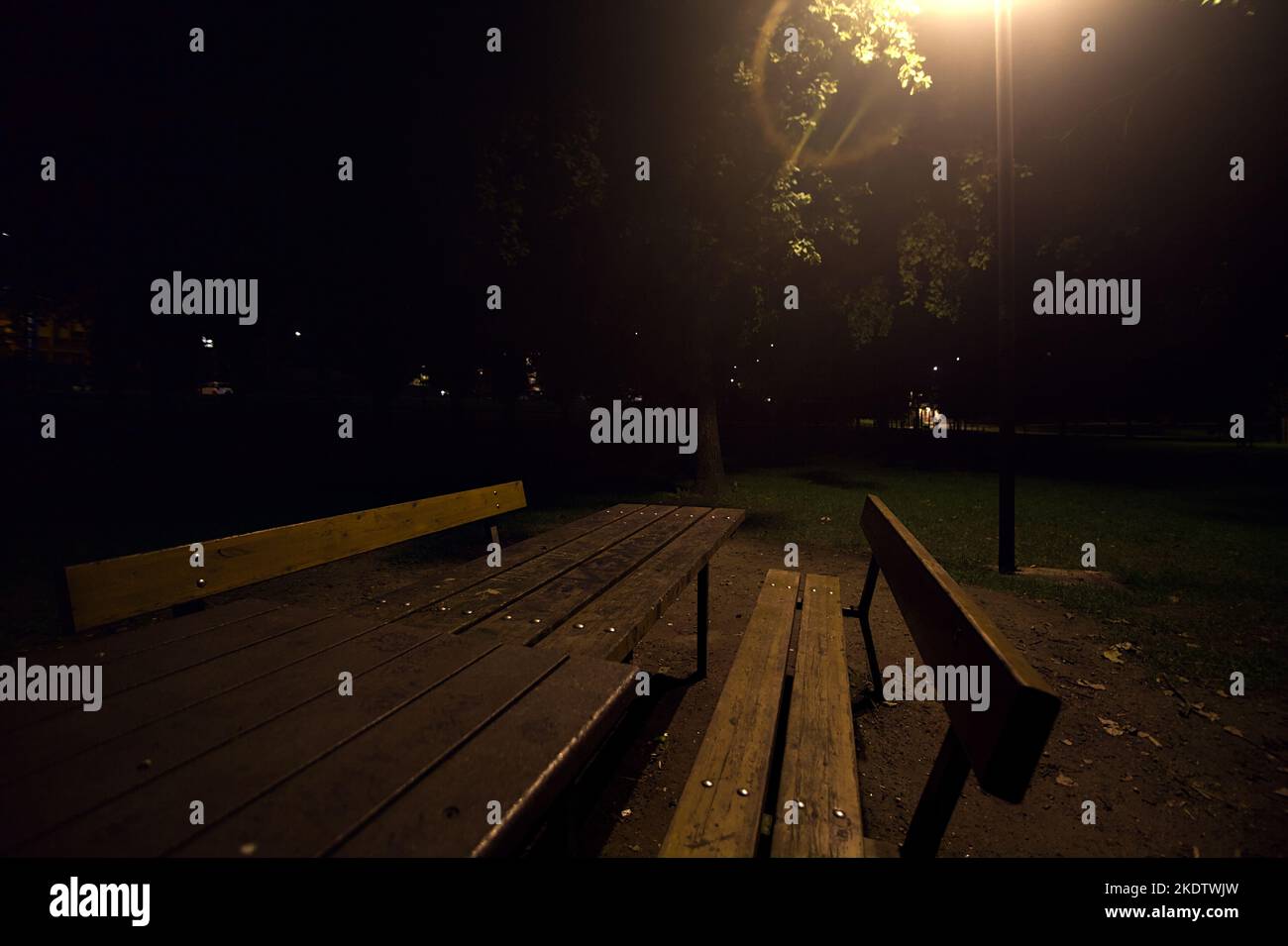 Wooden bench in a park under a street light at night Stock Photo - Alamy