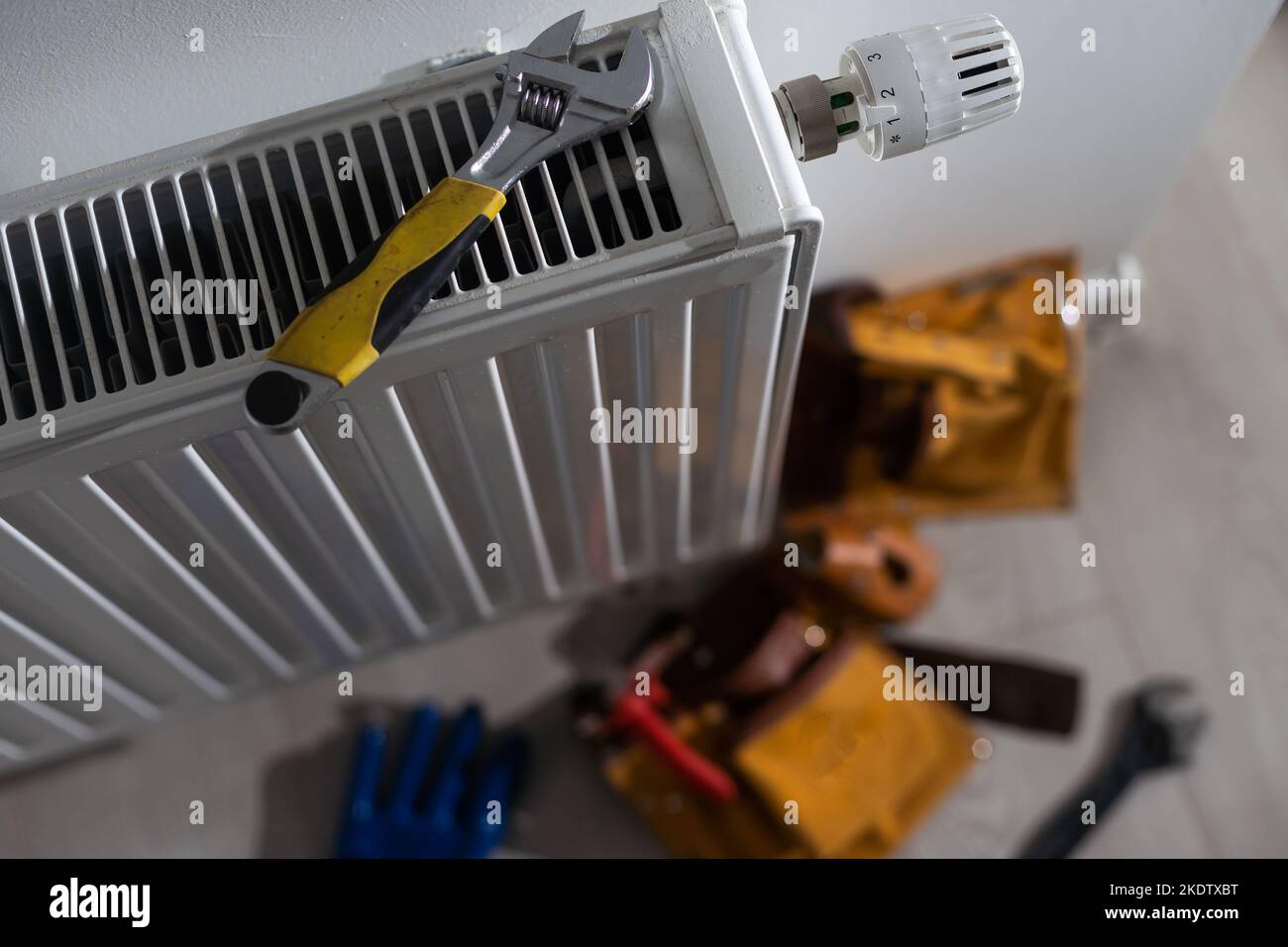 tools on the radiator. water heating radiator on the white wall indoors ...