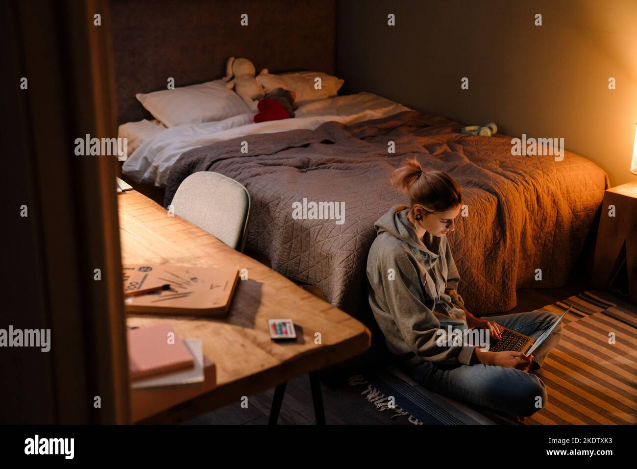 White girl with tunnel rings using laptop while sitting on floor at ...