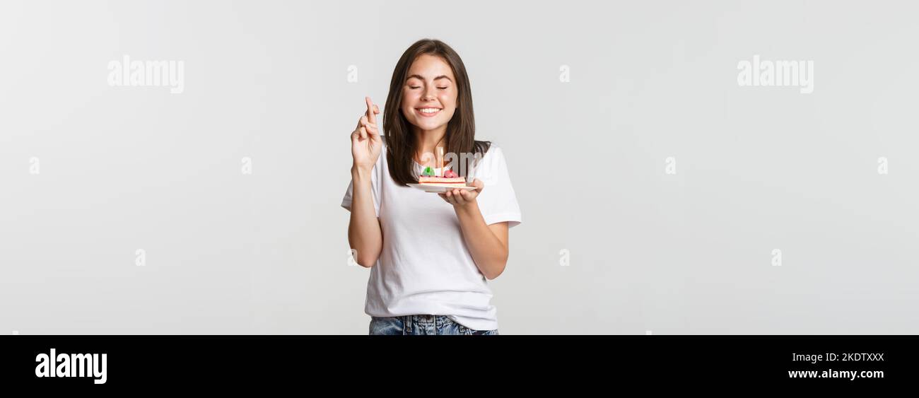 Hopeful and happy smiling birthday girl cross fingers and making wish ...