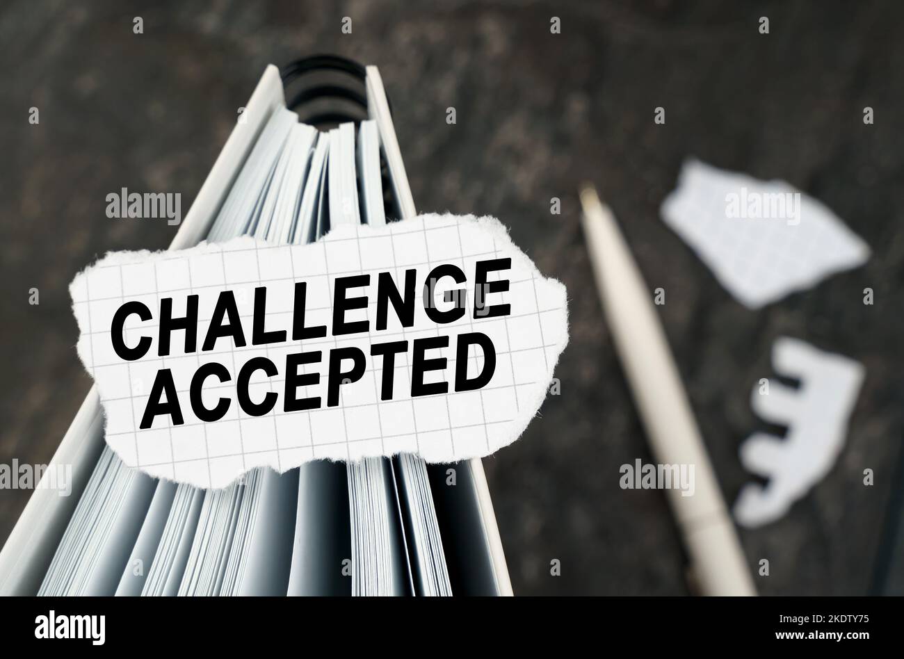 On the table is a notebook on which lies a piece of torn paper with the ...