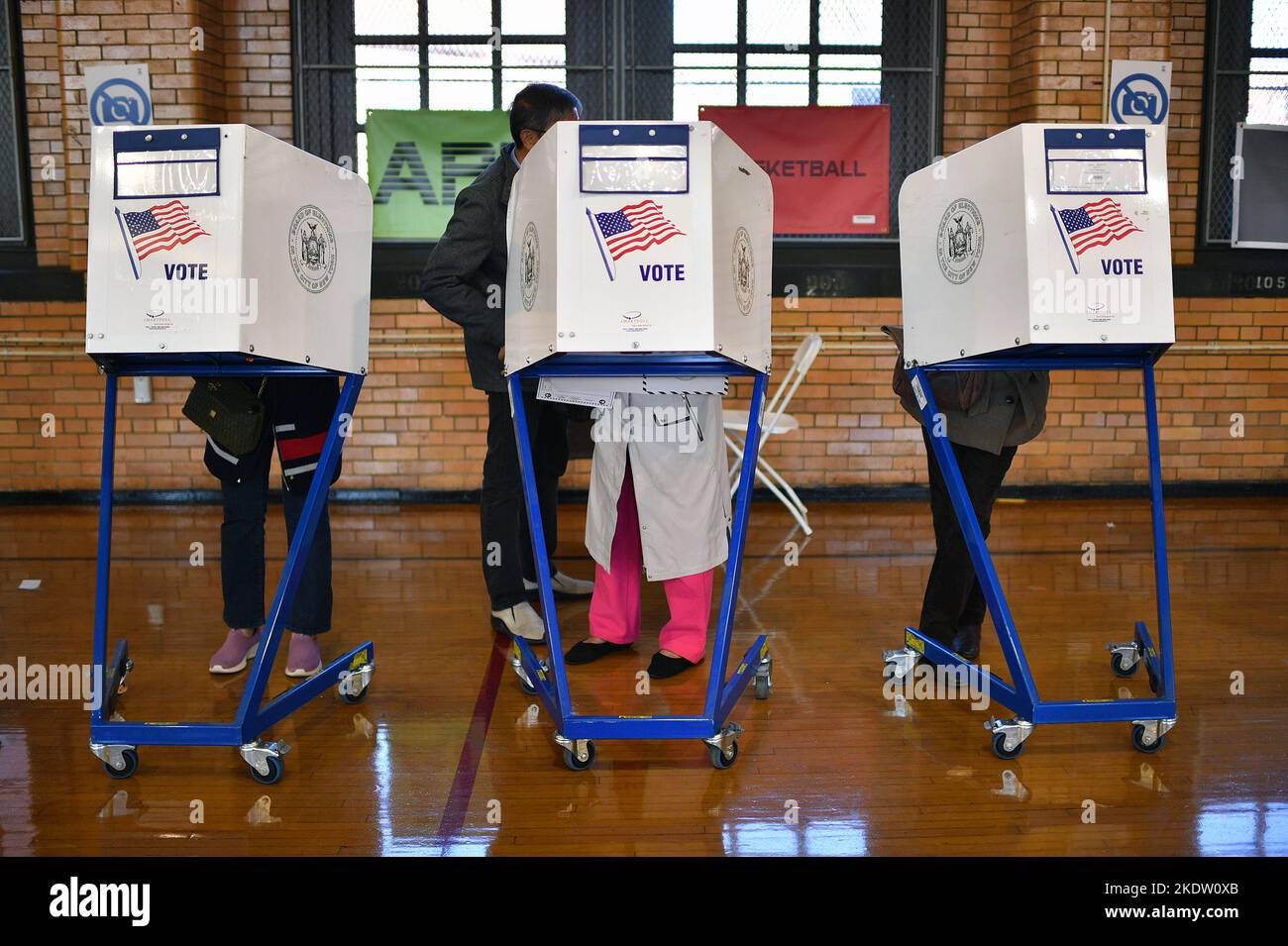 People stand behind a privacy booths to fill out their ballot before ...