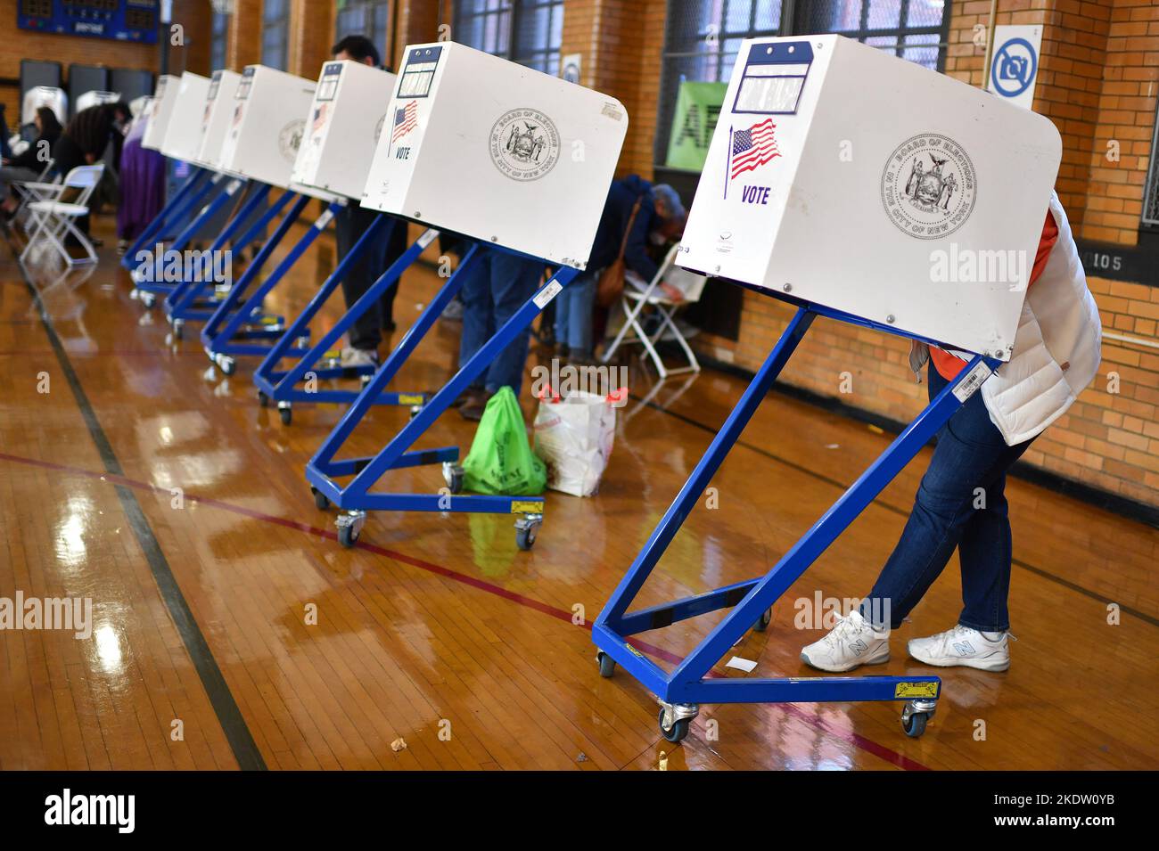 People stand behind a privacy booths to fill out their ballot before ...