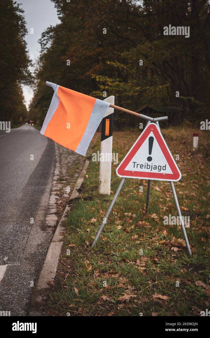 on the side of the road there is a sign with a flag with the warning ...