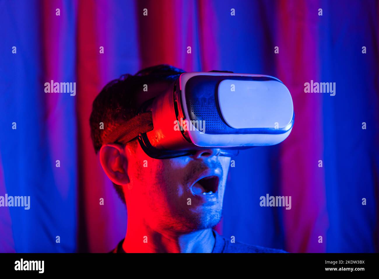 Asian handsome man wear VR helmet excited emotional at home purple and ...