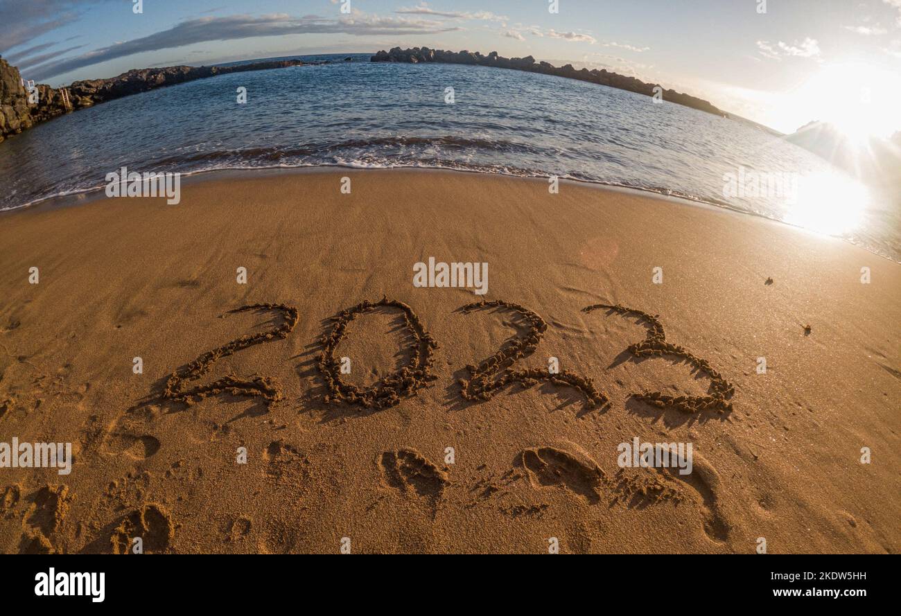 tropical New Year 2023 written in golden sand on the beach Stock Photo ...