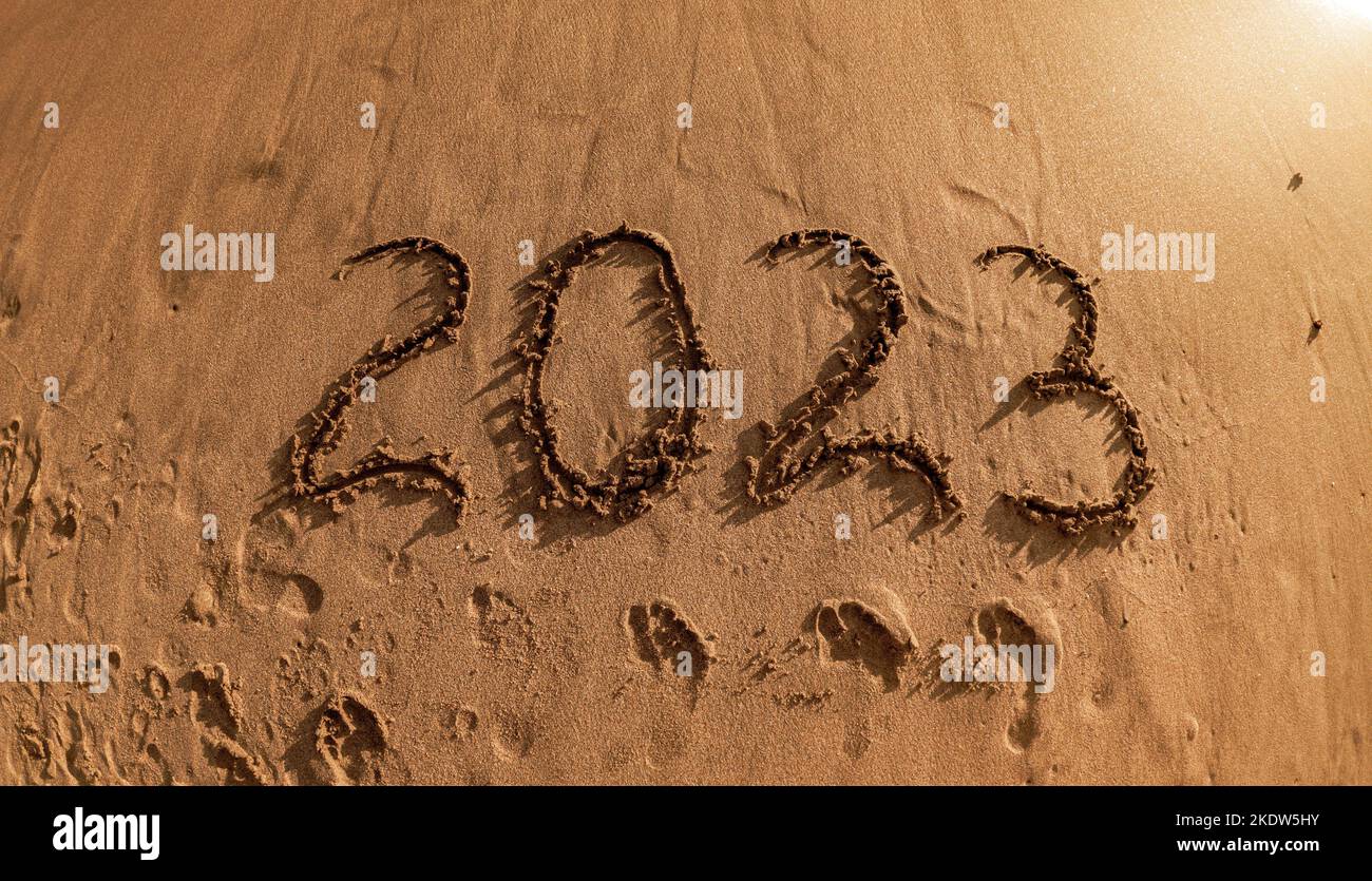 tropical New Year 2023 written in golden sand on the beach Stock Photo ...