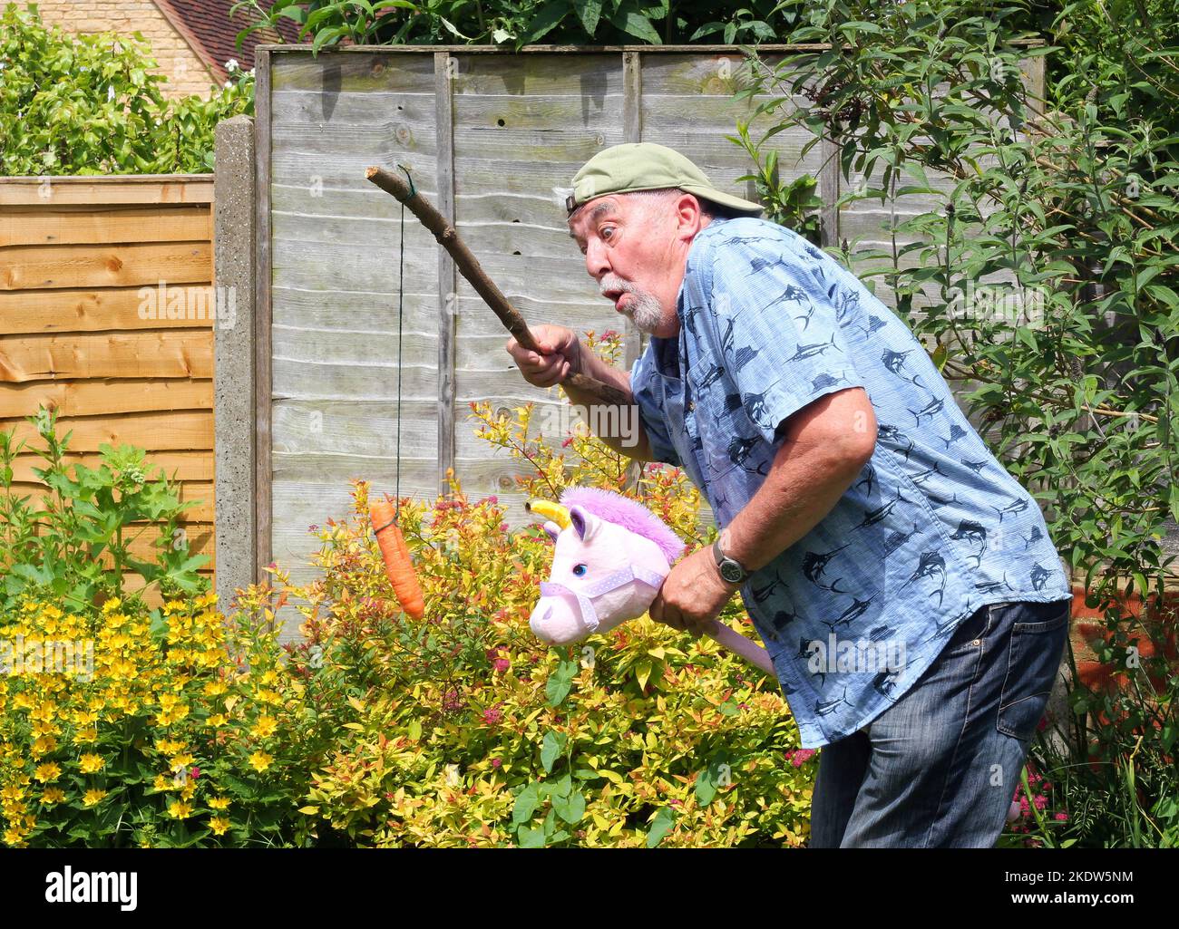 Senior or elderly man playing. Pretending to ride a horse and laughing ...