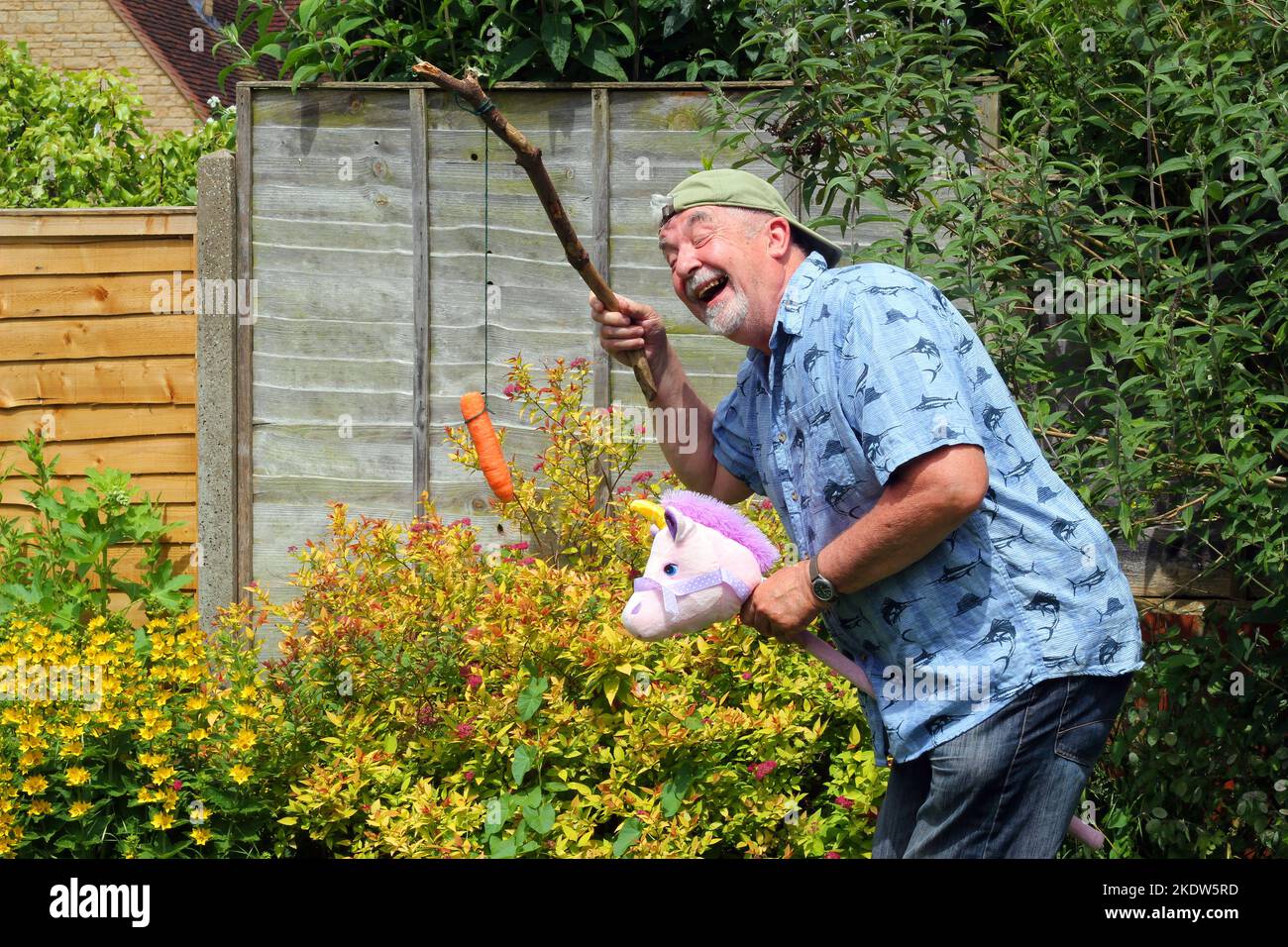 Senior or elderly man playing. Pretending to ride a horse and laughing ...
