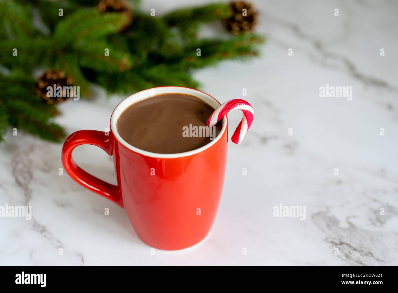 a red cup of hot chocolate with a candy cane, with Christmas ...
