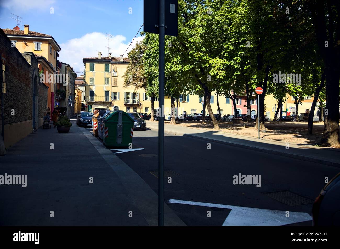 Square with trees seen from a pavement next to it Stock Photo - Alamy