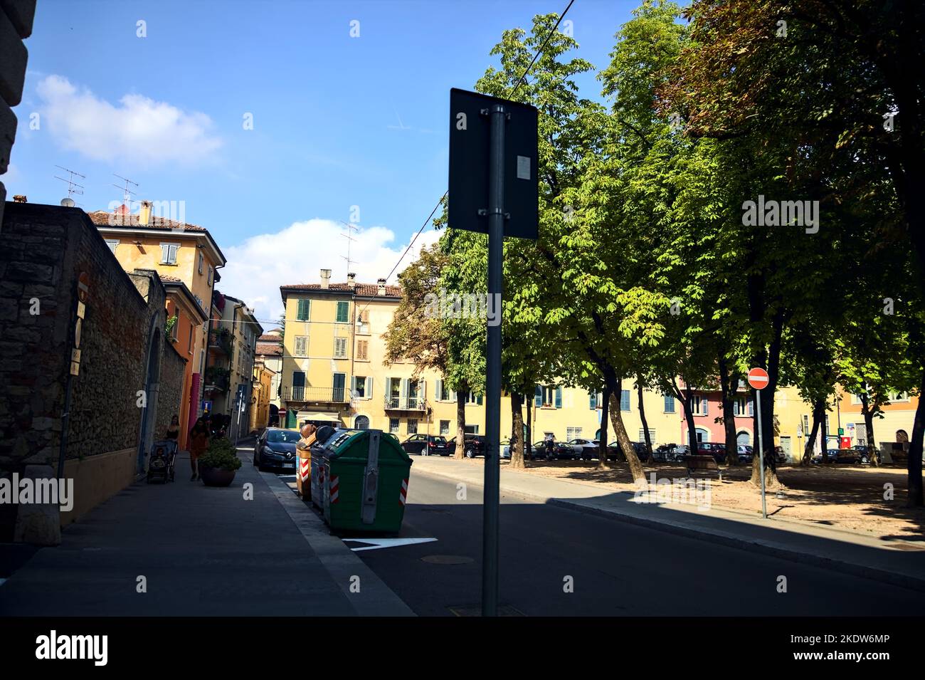 Square with trees seen from a pavement next to it Stock Photo - Alamy