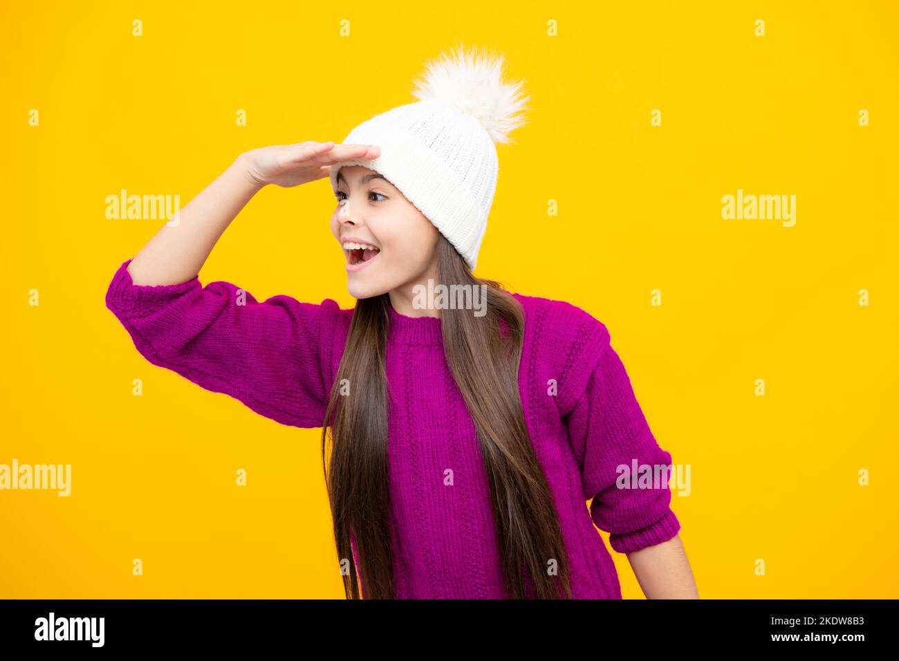 Teenager girl with winter hat over isolated yellow background. Winter ...