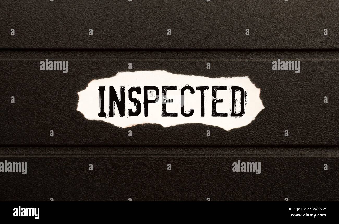 Yellow note paper with word inspection on cork board background with ...