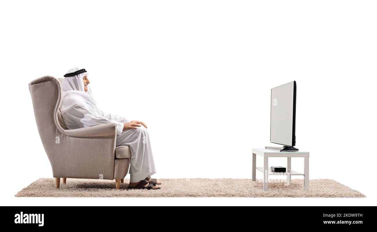 Arab man sitting in an armchair and watching tv isolated on white ...
