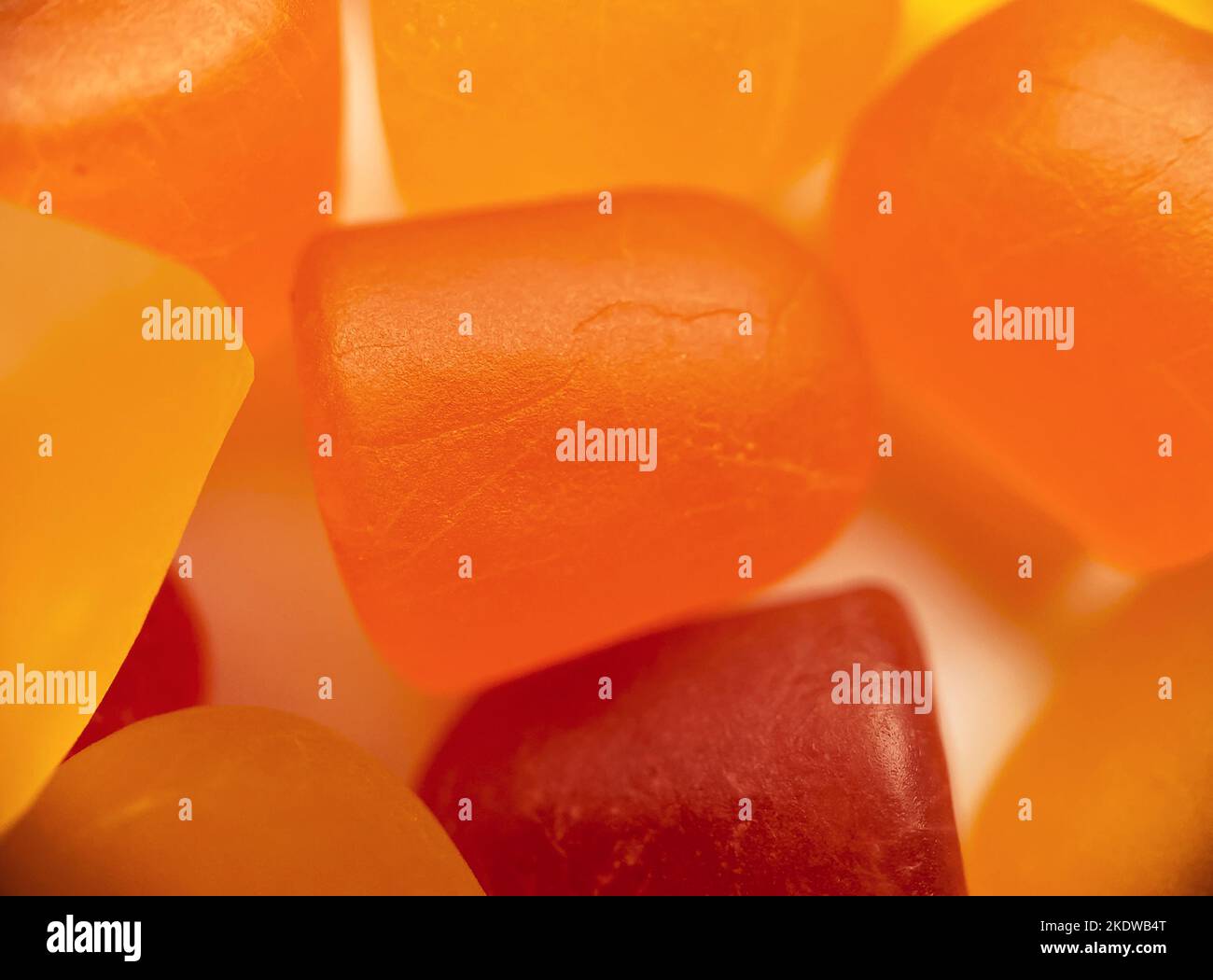 Close-up texture of orange and yellow multivitamin gummies on white ...