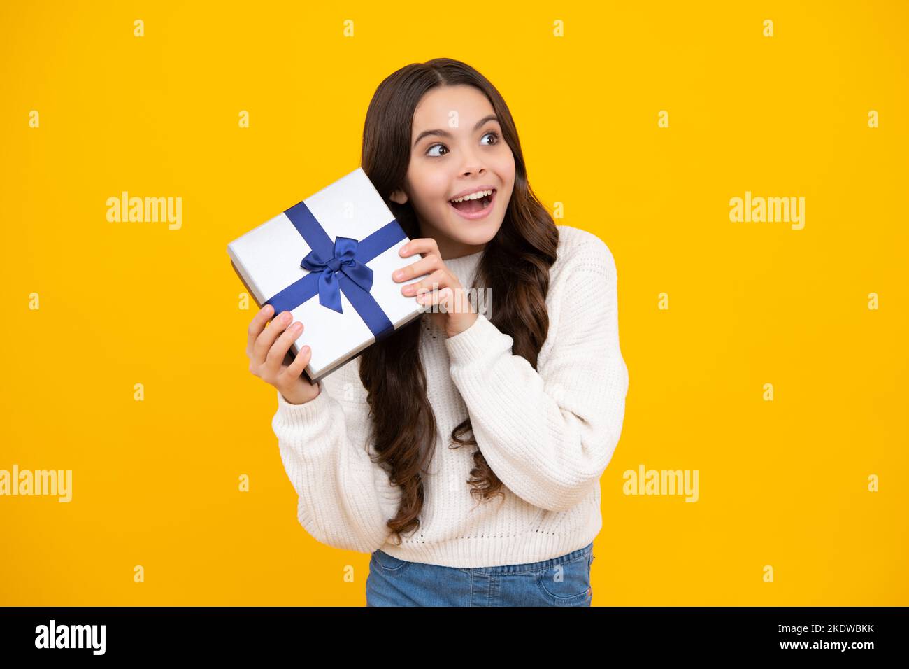 Child with gift present box on isolated studio background. Gifting for ...