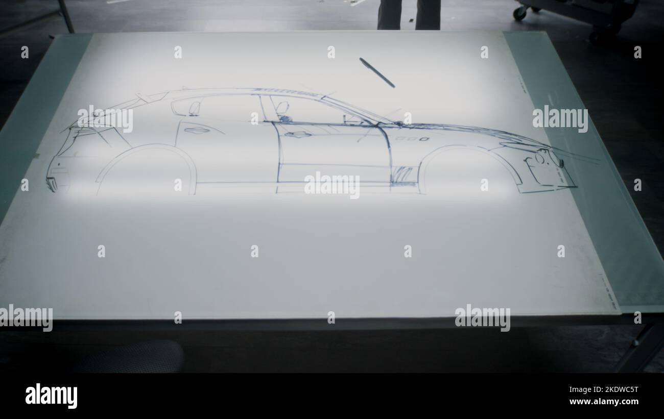 Senior automotive male designer drawing car body sketch with marker at ...