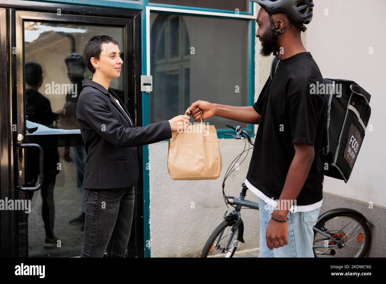 Food delivery service courier giving customer order package. African ...