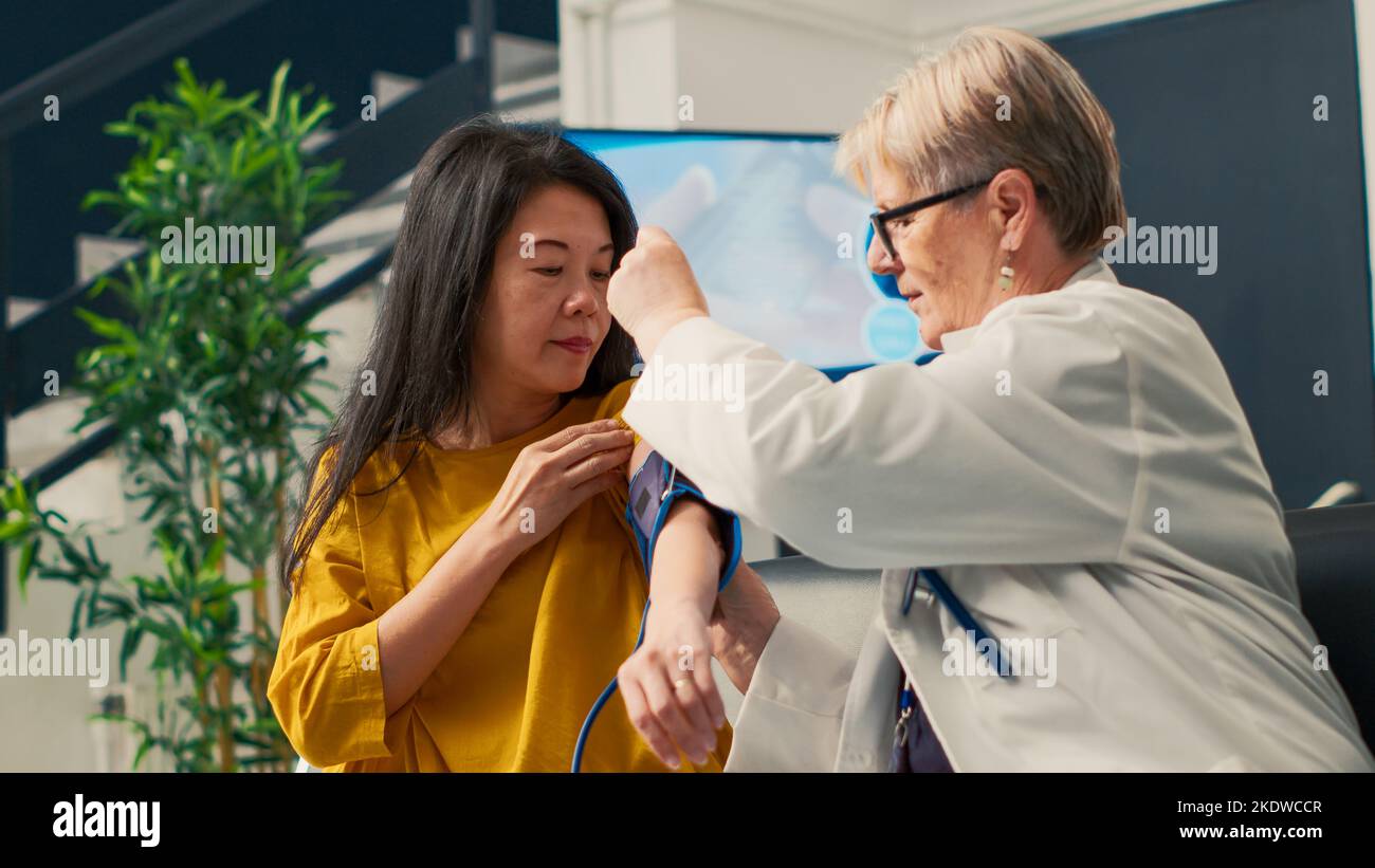 Elderly medic measuring hypertension and pulse pressure with tonometer ...