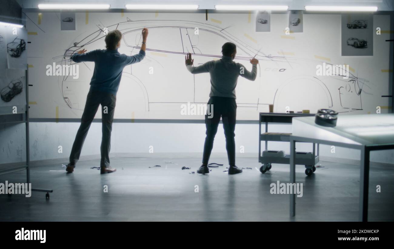 Two diverse automotive male designers drawing sketch with marker on ...