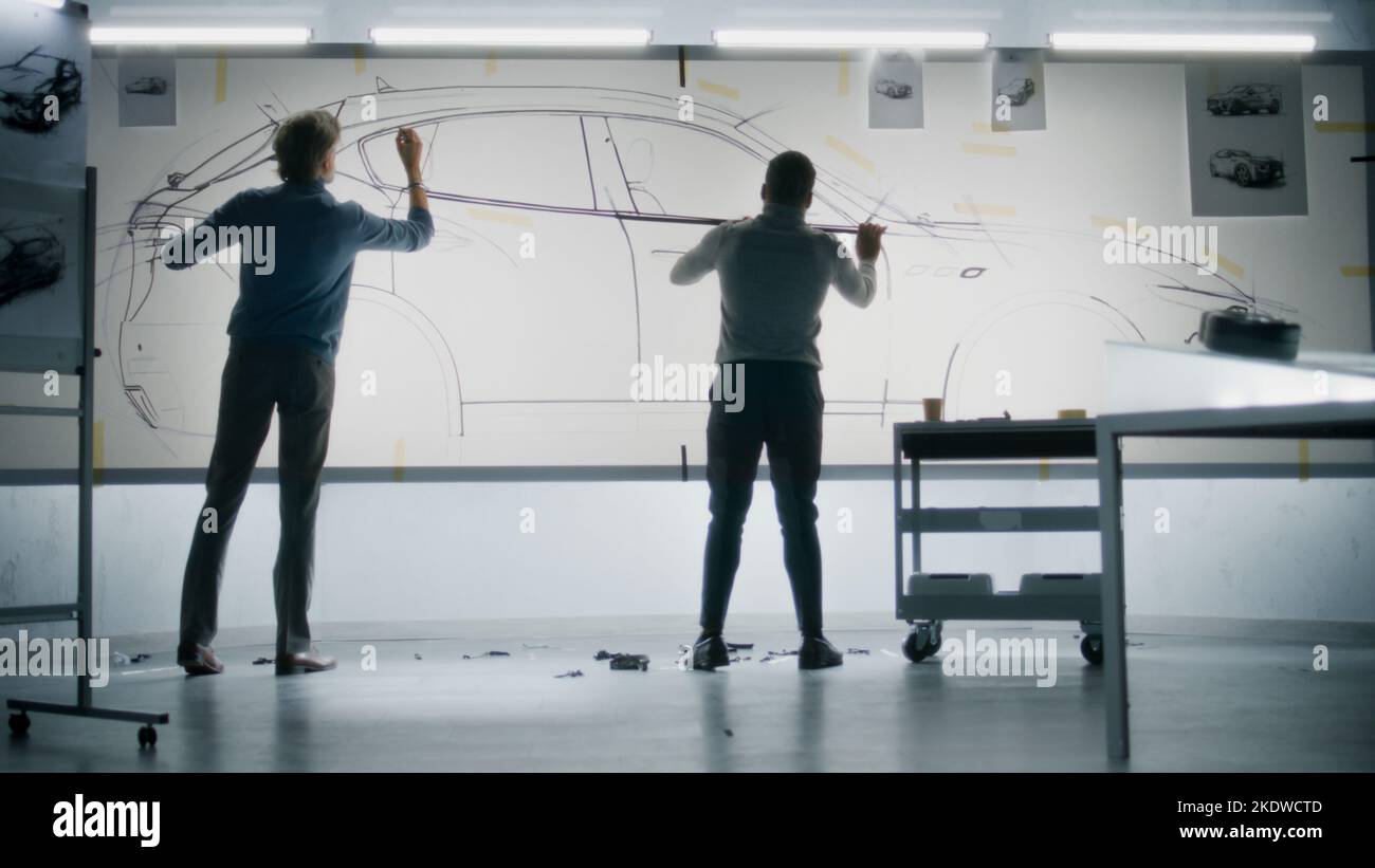 Two diverse automotive male designers drawing sketch with marker on ...