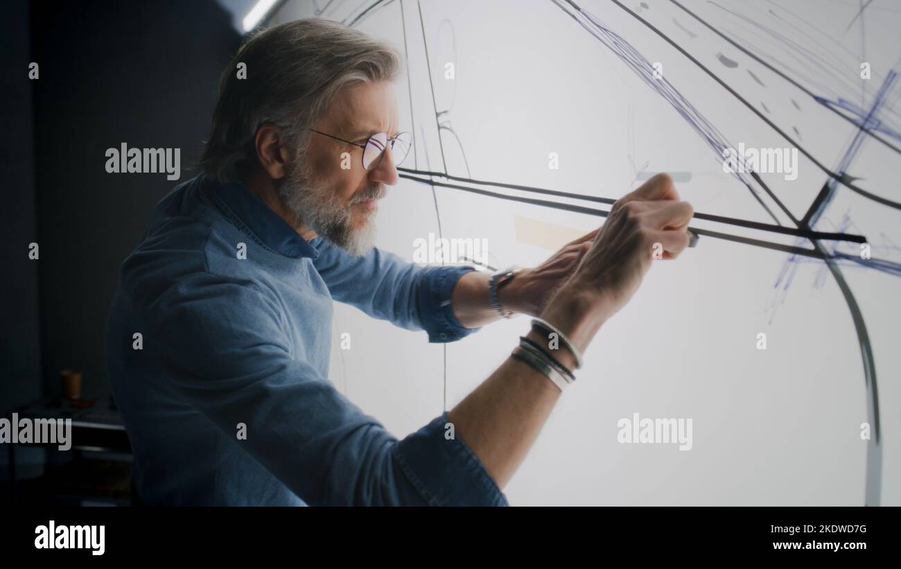 Automotive male engineer creating sketch with duct tape on paper ...